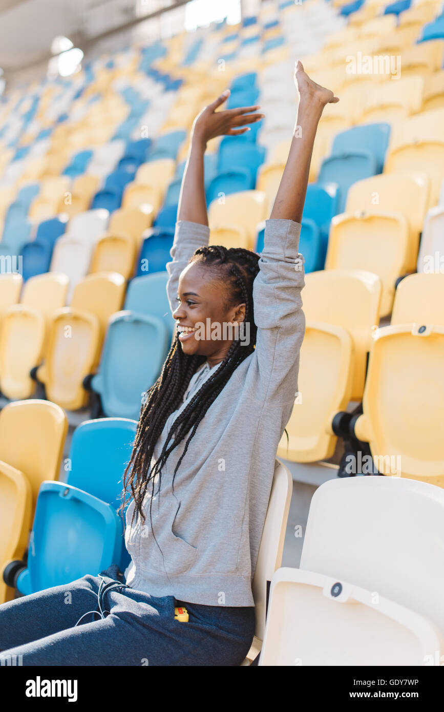 Fans: excited female fan sits alone way up in the high seats, side view ...