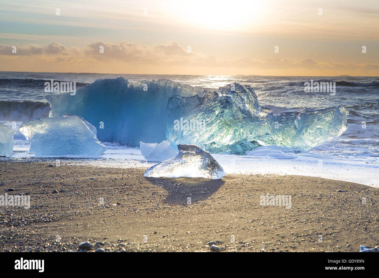 Big chunks of glacial ice slowly melting in the sand on a beach in ...