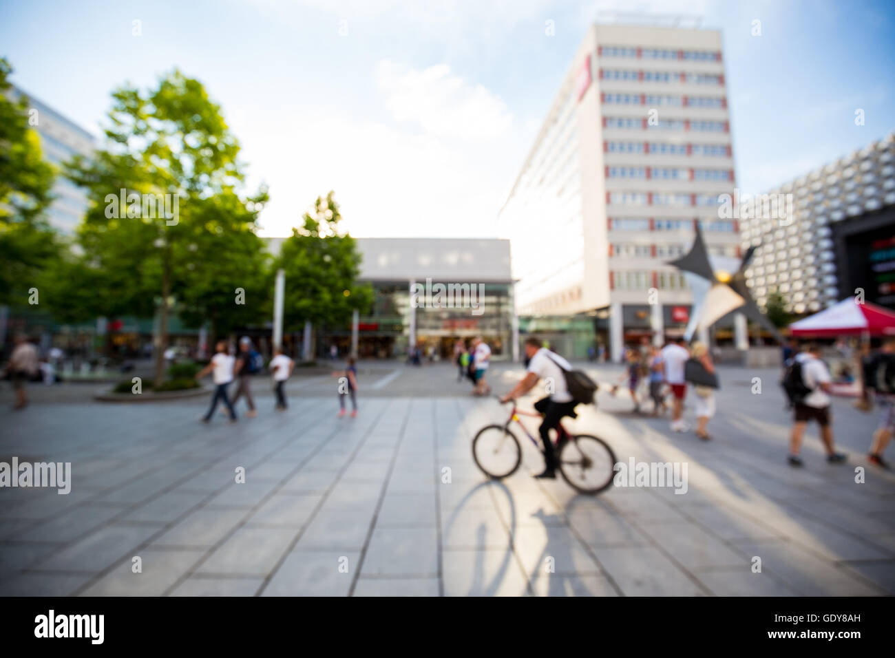 Out of focus street scene from a city center in summer, pedestrians ...