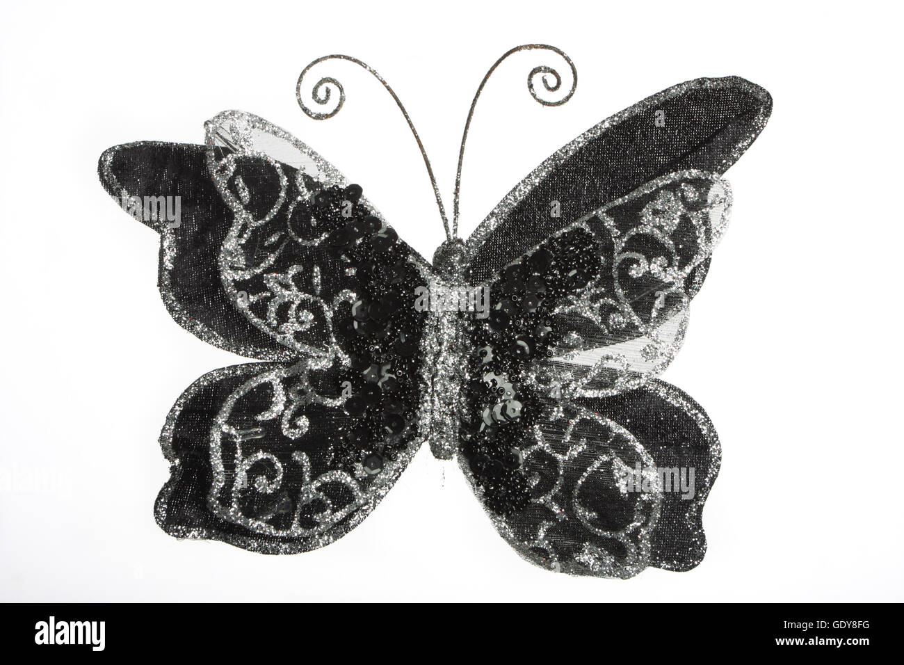 Decorative black and silver butterfly set against að white background ...
