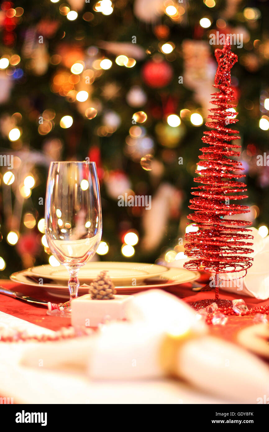 set christmas dinner table, decorated christmas tree in background ...