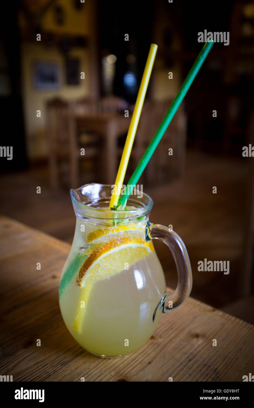 Lemonade pitcher with drinking straws shot in a restaurant Stock Photo ...