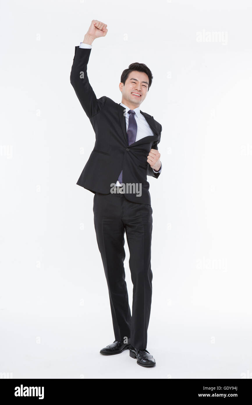 Smiling business man in suit standing cheering Stock Photo - Alamy