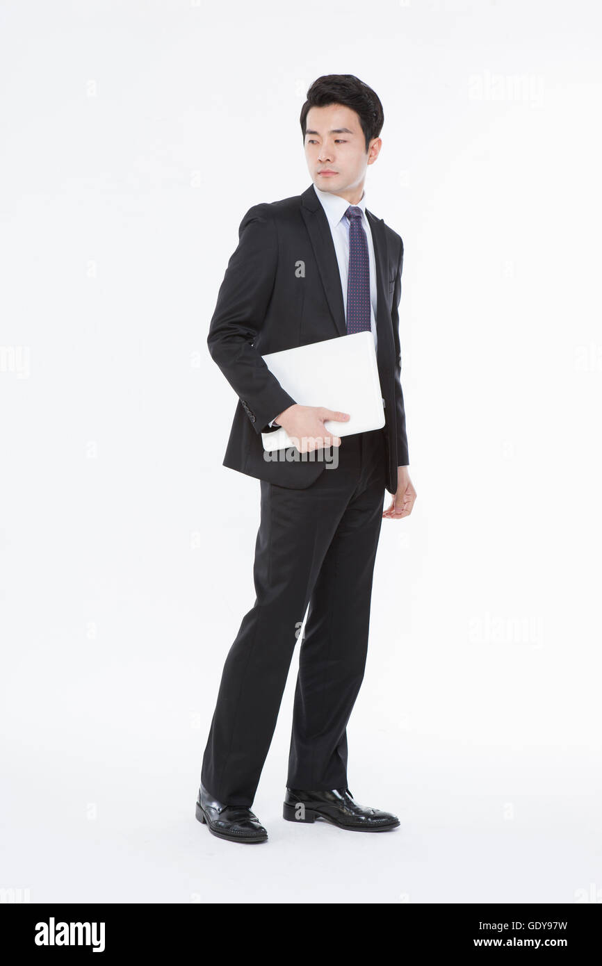 Side view of business man with a notebook computer standing looking ...