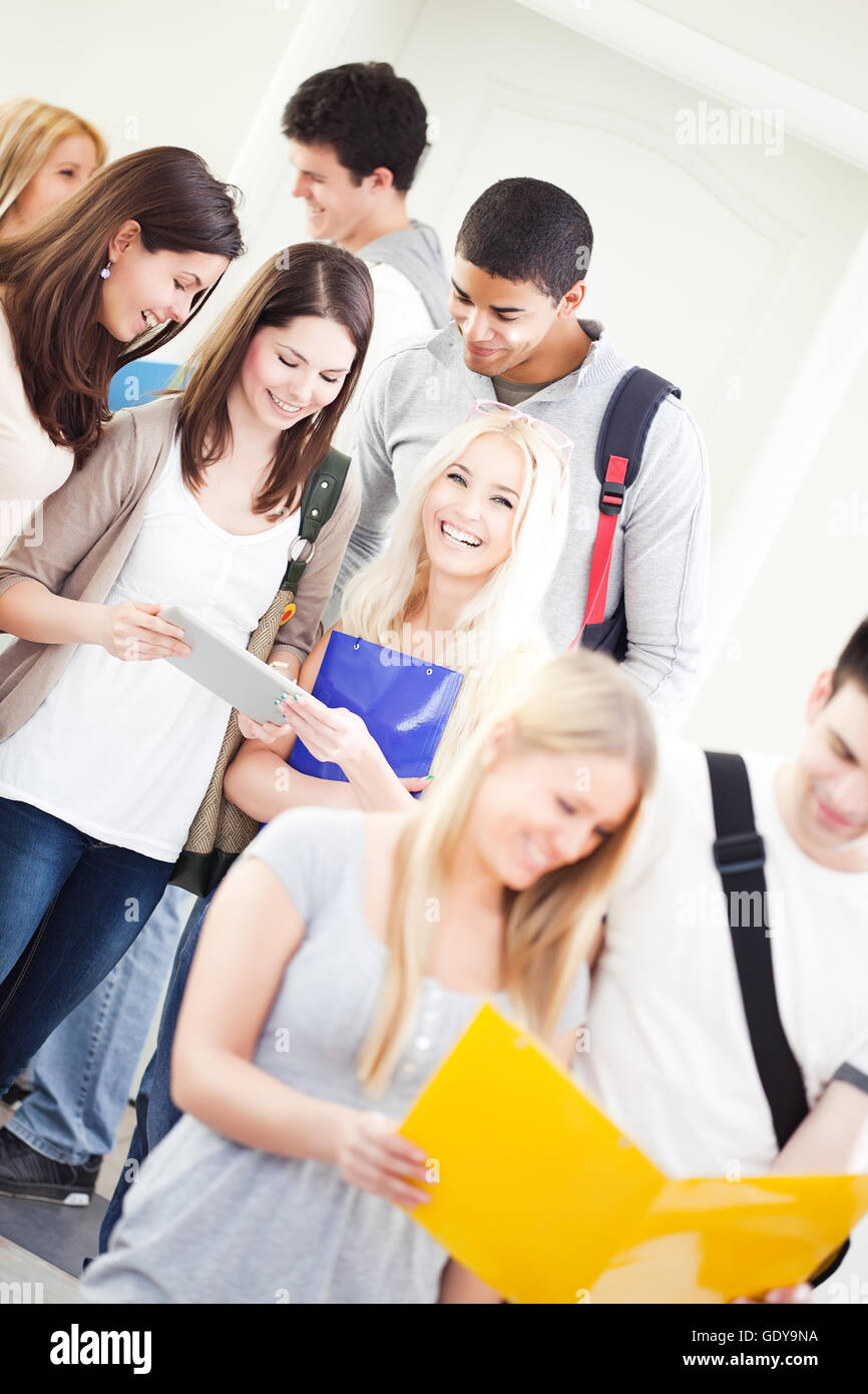 Large group of university students standing together in the hallway ...