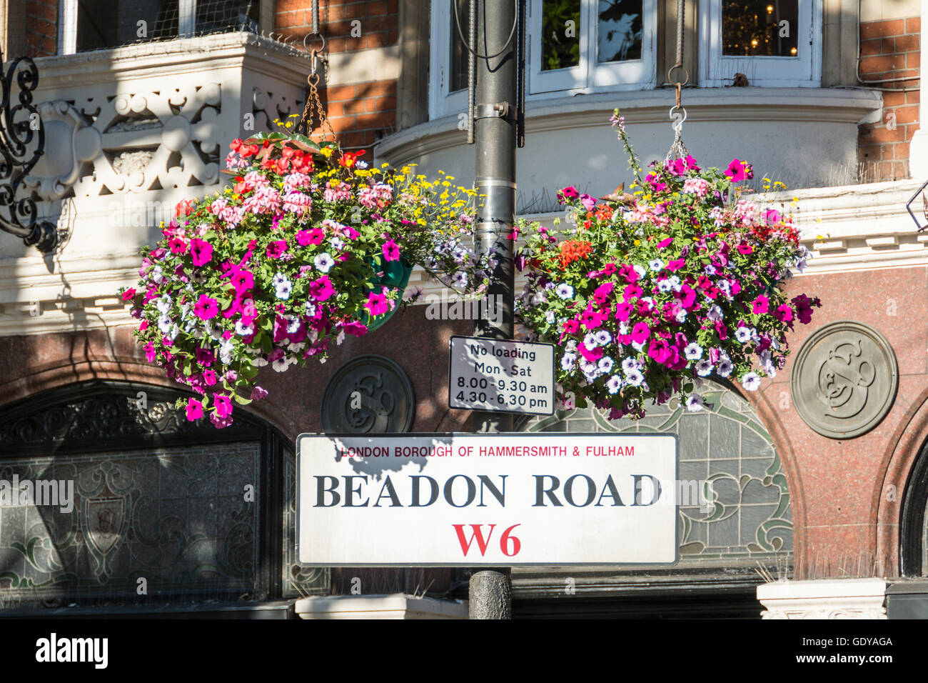 A colourful hanging basket and road sign in Beadon Road, Hammersmith ...
