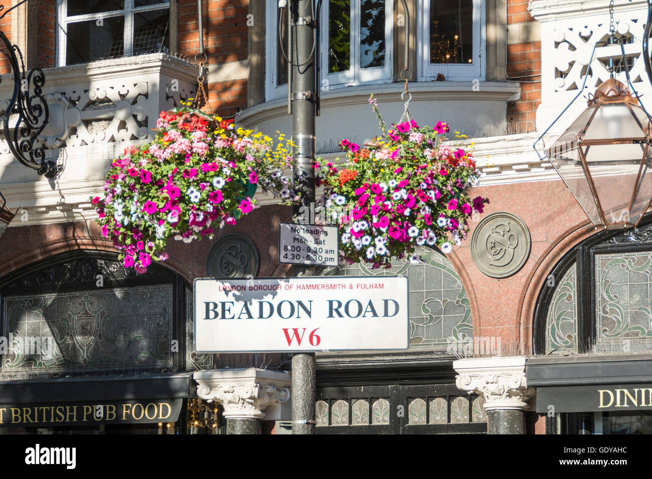 A colourful hanging basket and road sign in Beadon Road, Hammersmith ...