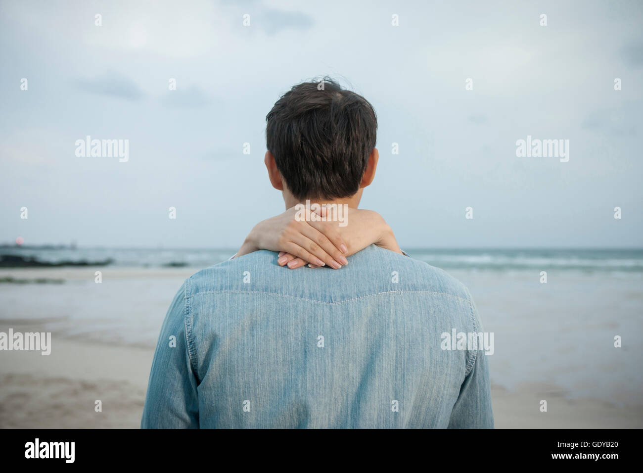 Back portrait of young man hugging against beach Stock Photo - Alamy
