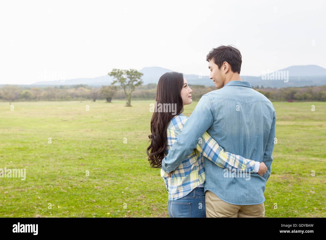 Back of young smiling couple hugging each other face to face on ...