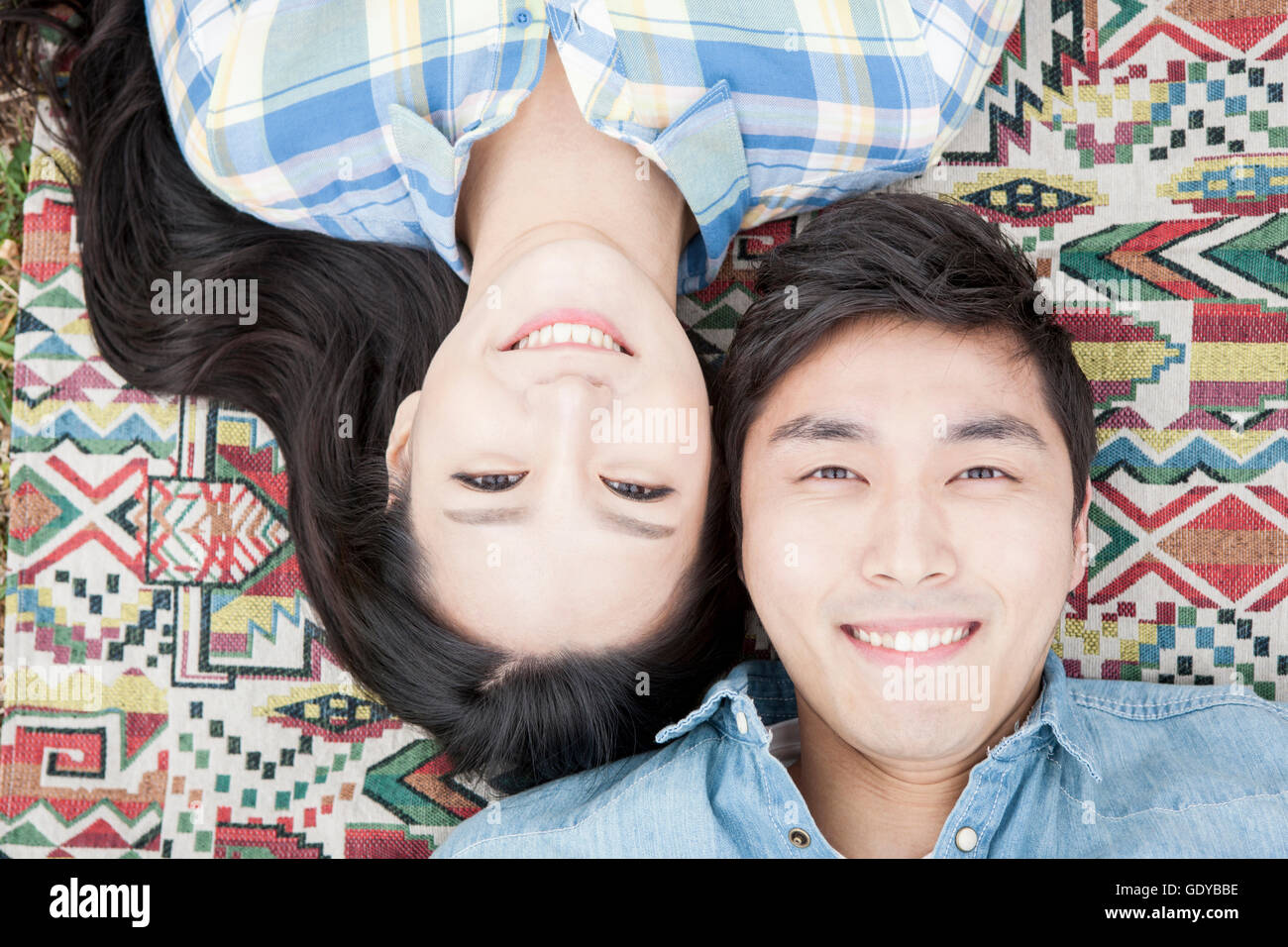 Portrait of young smiling couple lying down Stock Photo - Alamy