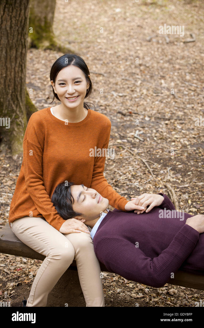 Young romantic couple having a date on bench in forest in fall Stock ...
