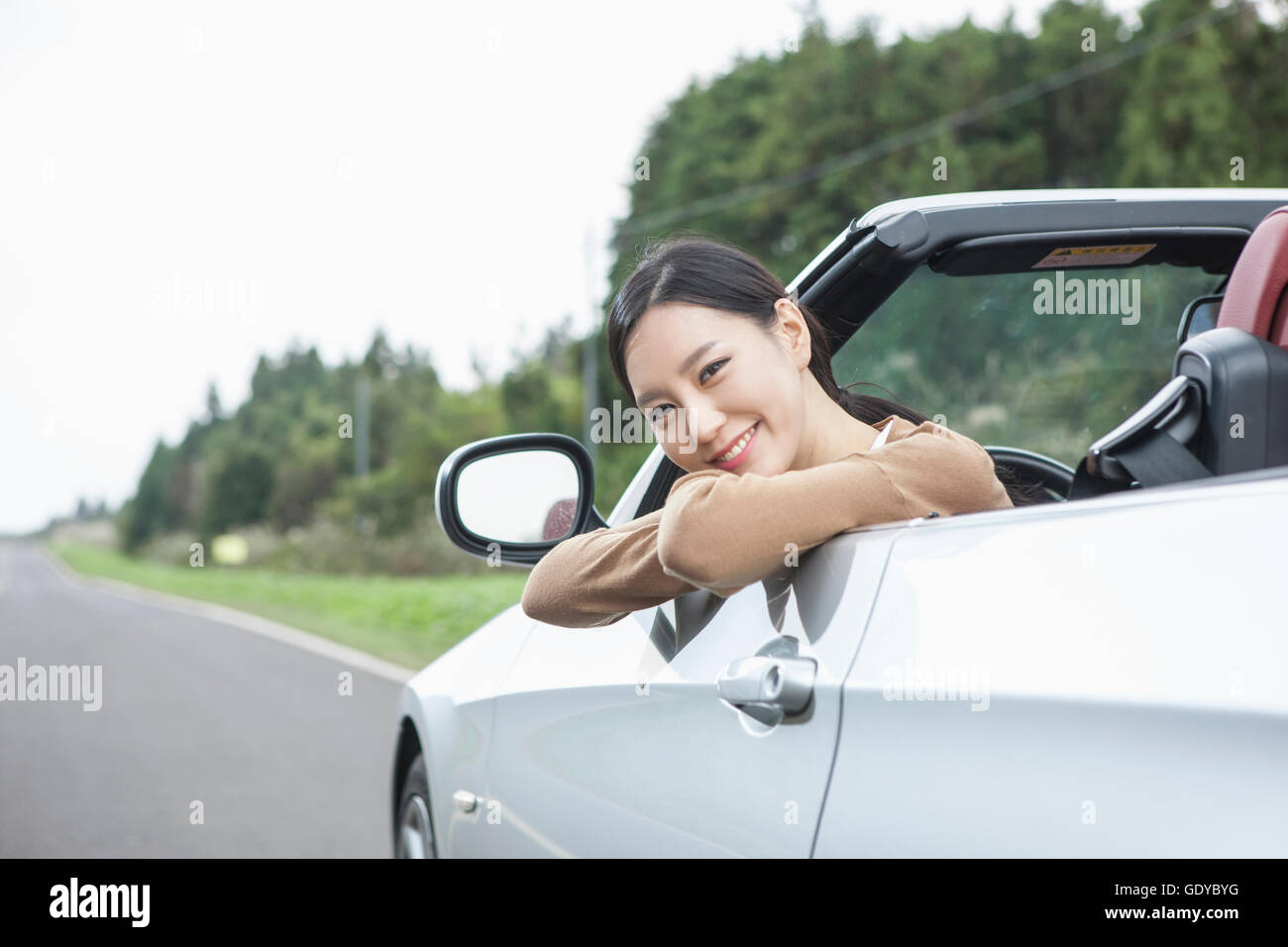 Side view portrait of young smiling woman in a car looking out Stock ...