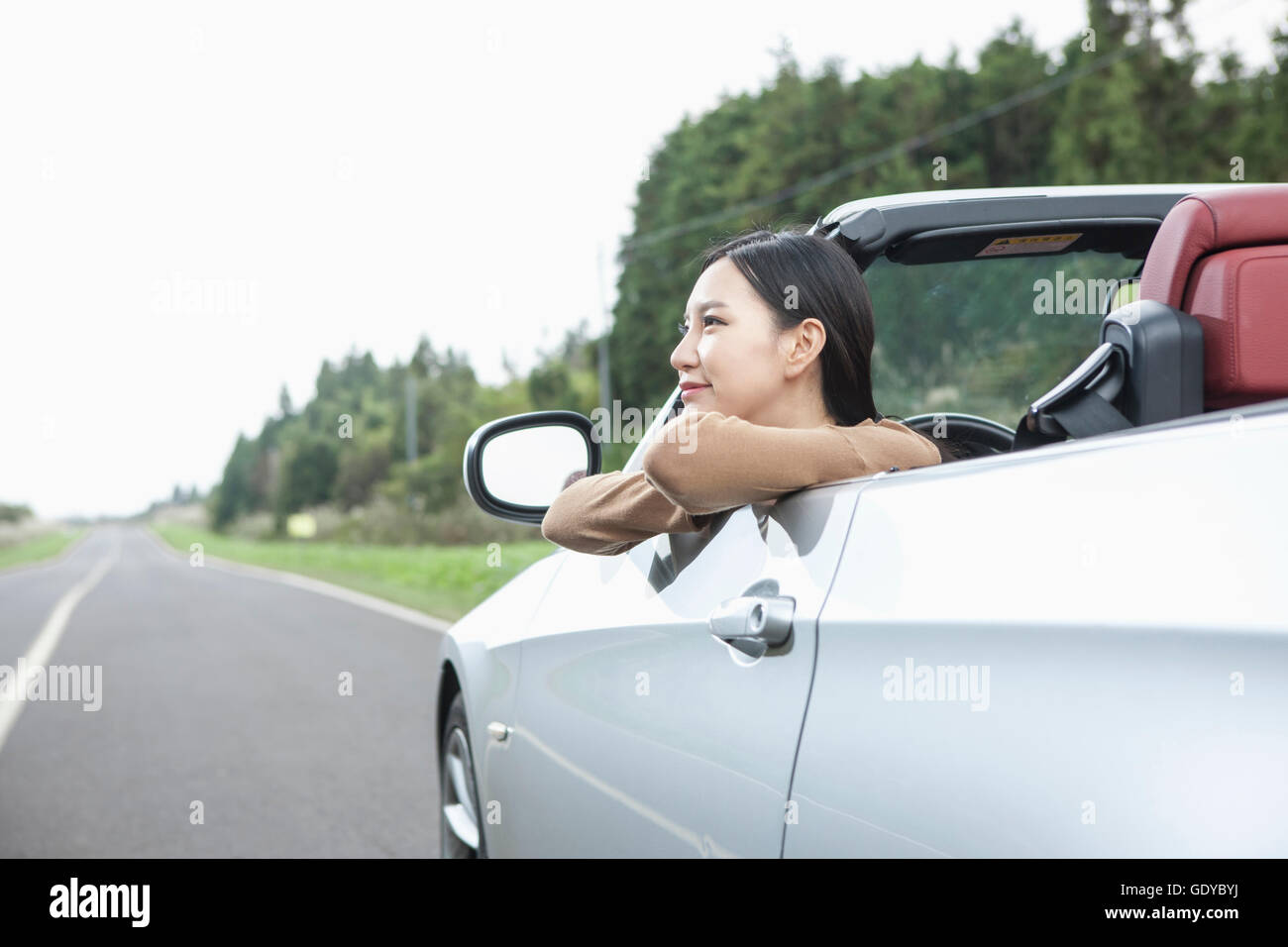 Side view portrait of young smiling woman in a car looking out Stock ...