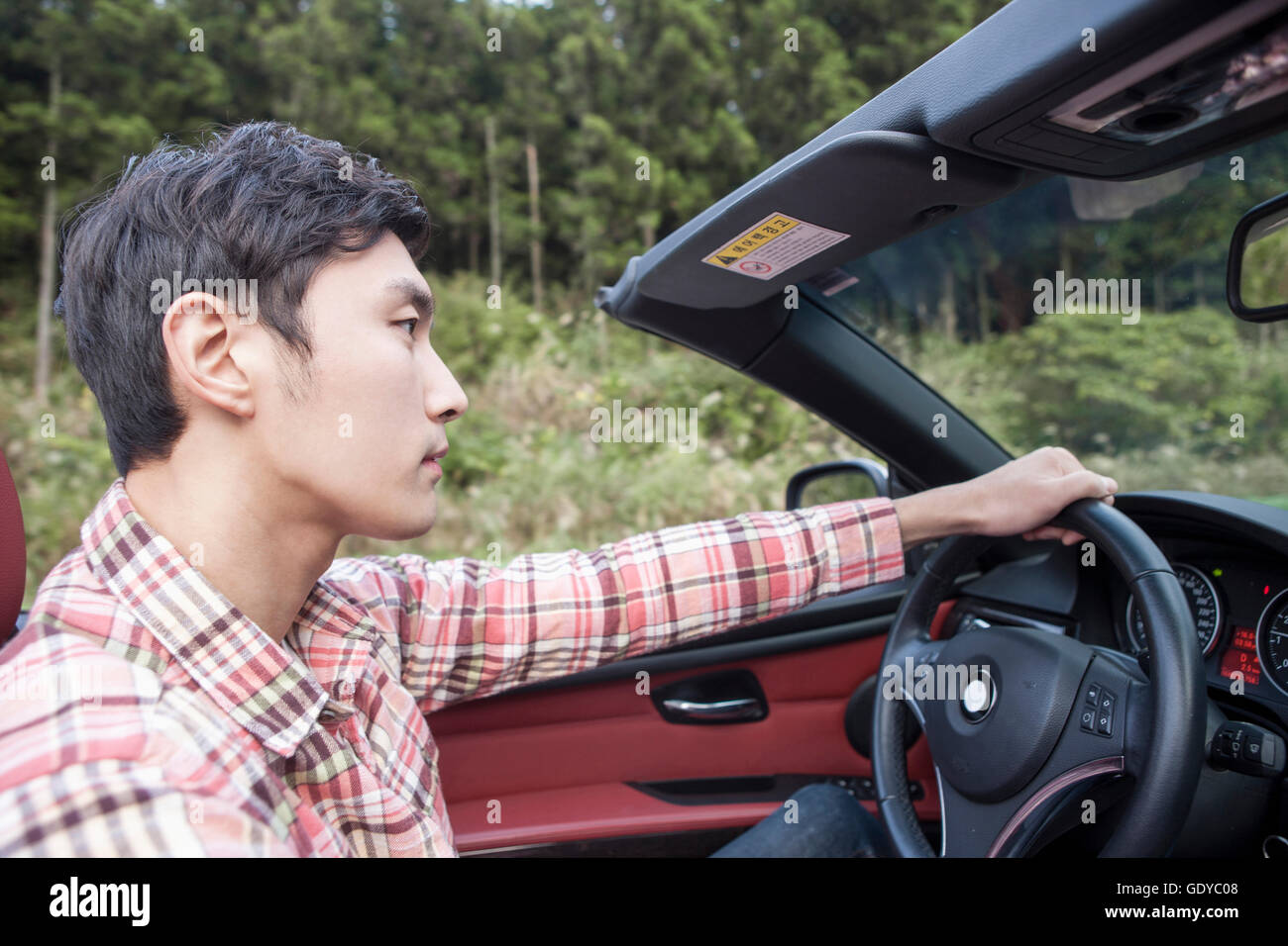 Side view portrait of young man driving a car Stock Photo - Alamy