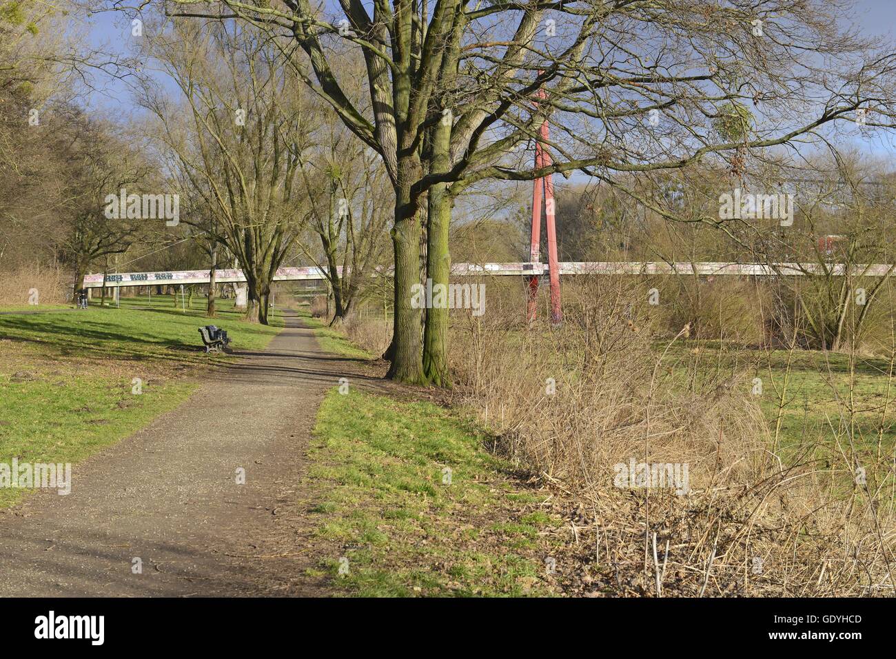 Trees and benches by the footpath at the riverside of the river Ihme ...