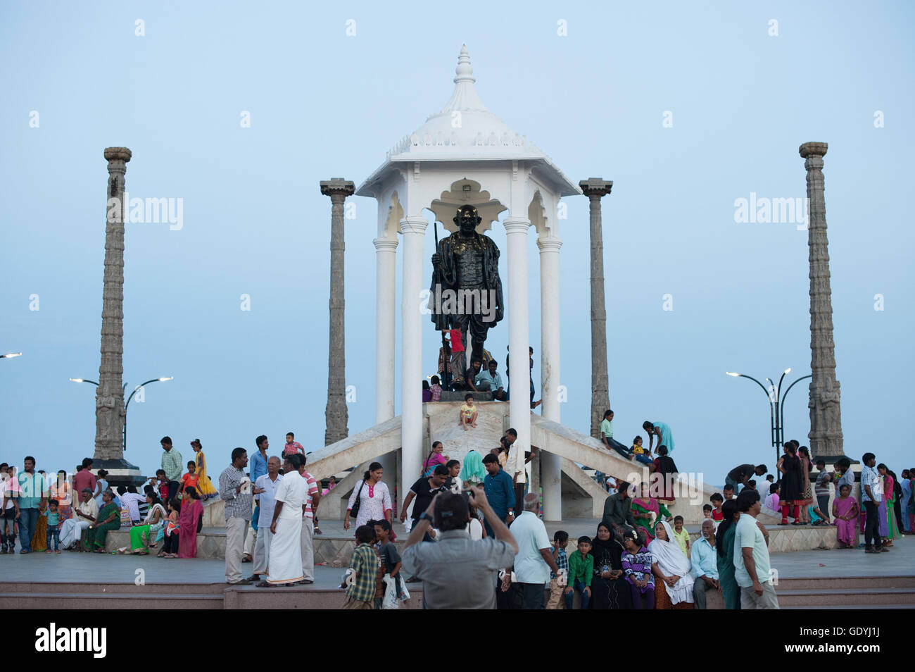 Locals and tourists are standing in front of a Gandhi statue in ...