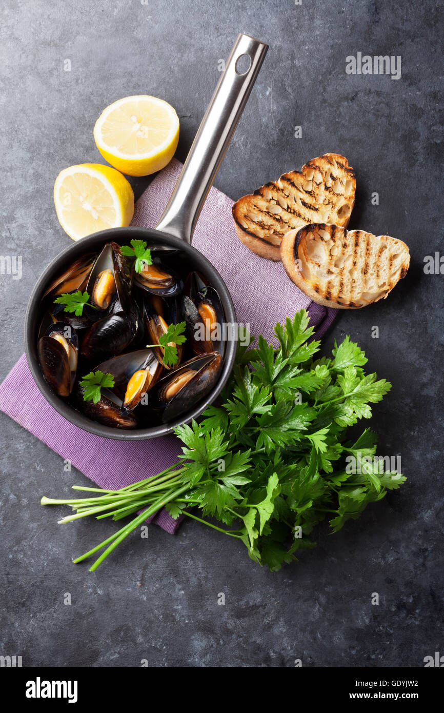 Mussels and bread toasts on stone table. Top view Stock Photo - Alamy