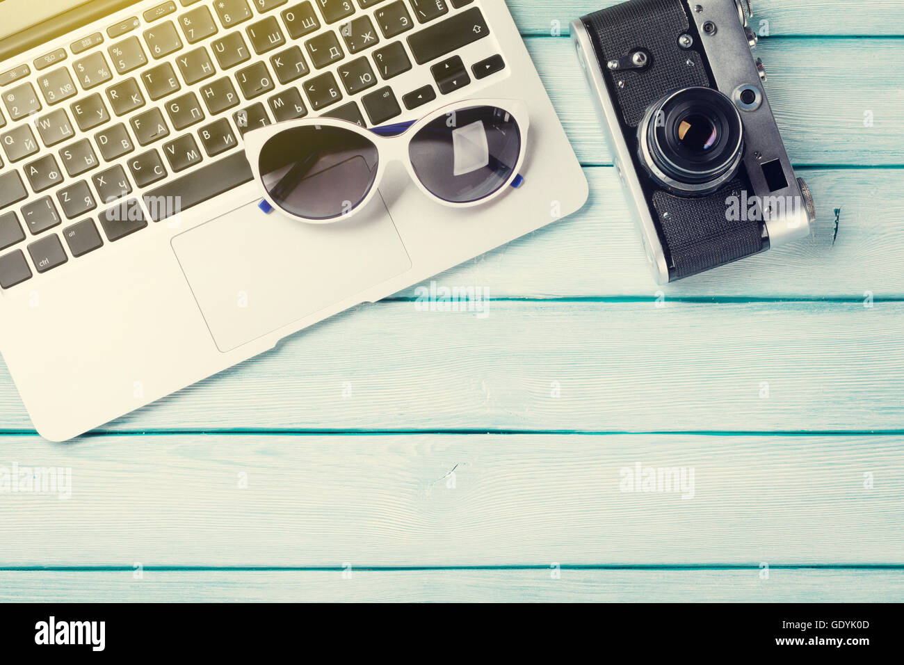 Desk table with laptop and camera on wooden table with sun beam ...