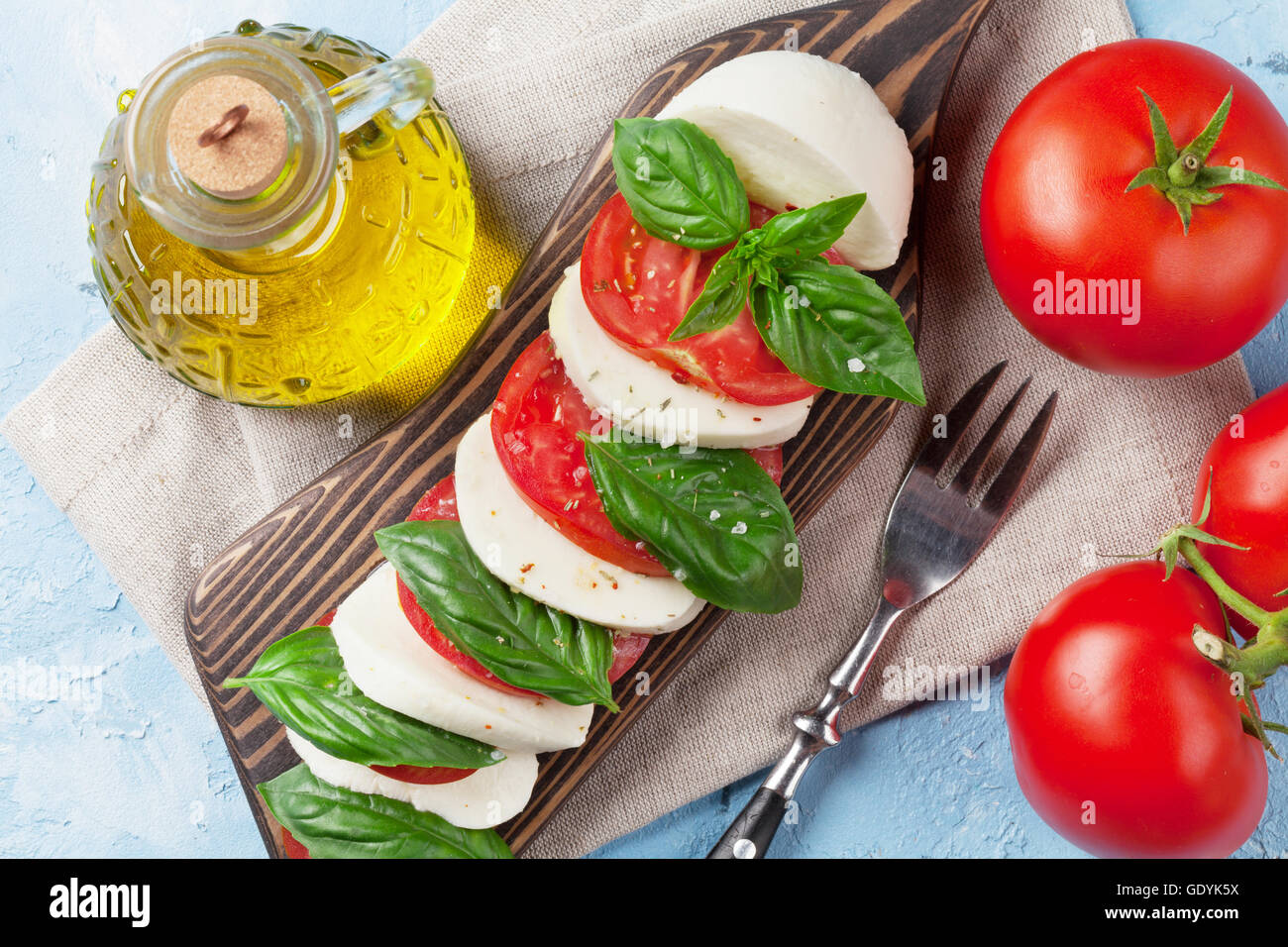 Caprese salad. Mozzarella cheese, tomatoes and basil herb leaves on ...
