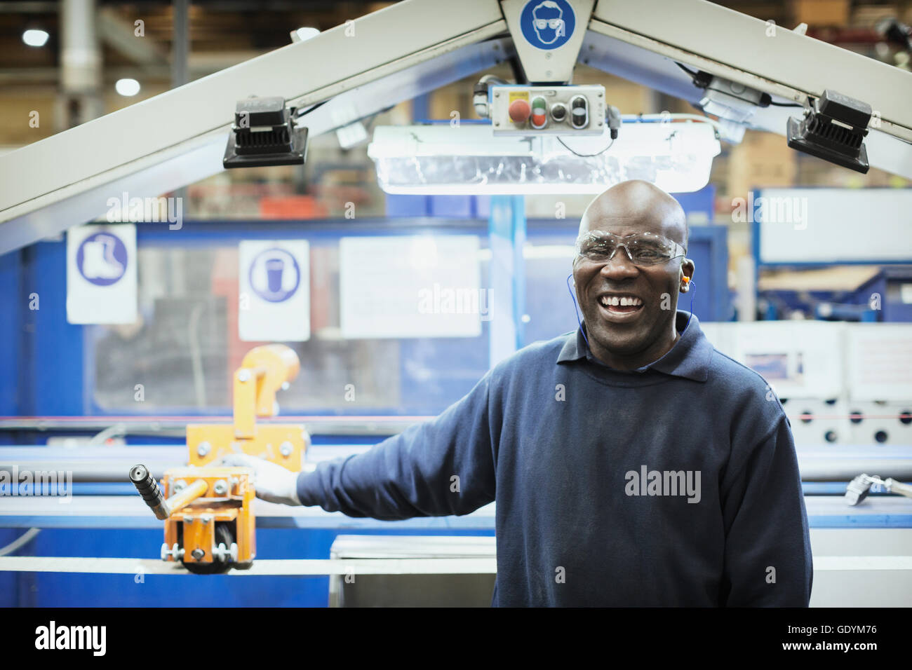 Portrait smiling worker at machine in steel factory Stock Photo - Alamy
