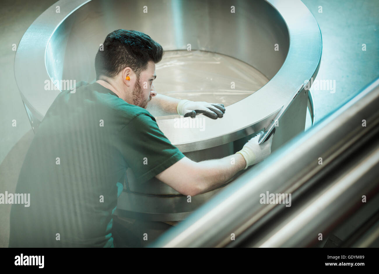 Worker inspecting part in steel factory Stock Photo - Alamy