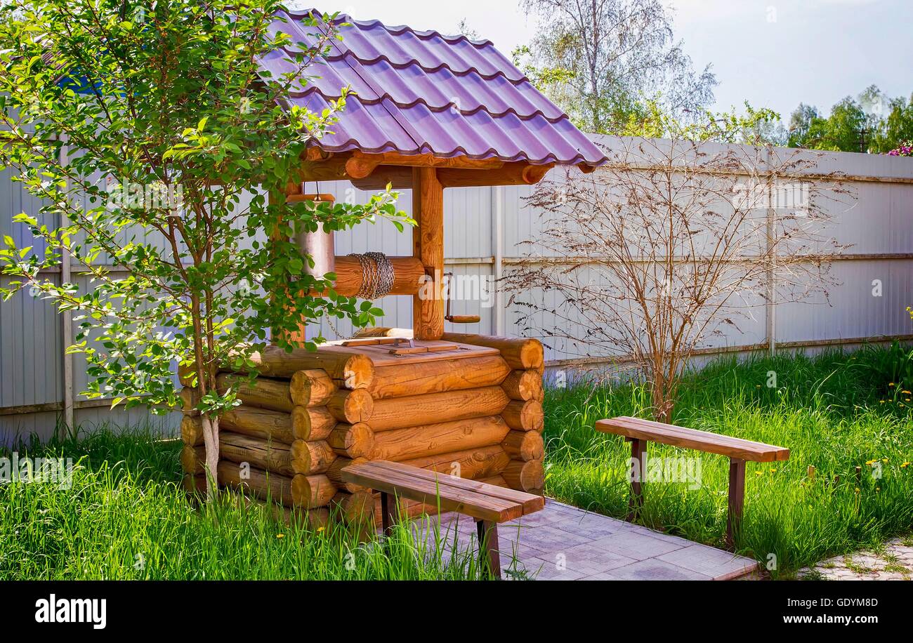 Beautiful well-maintained wooden well with a bucket Stock Photo - Alamy