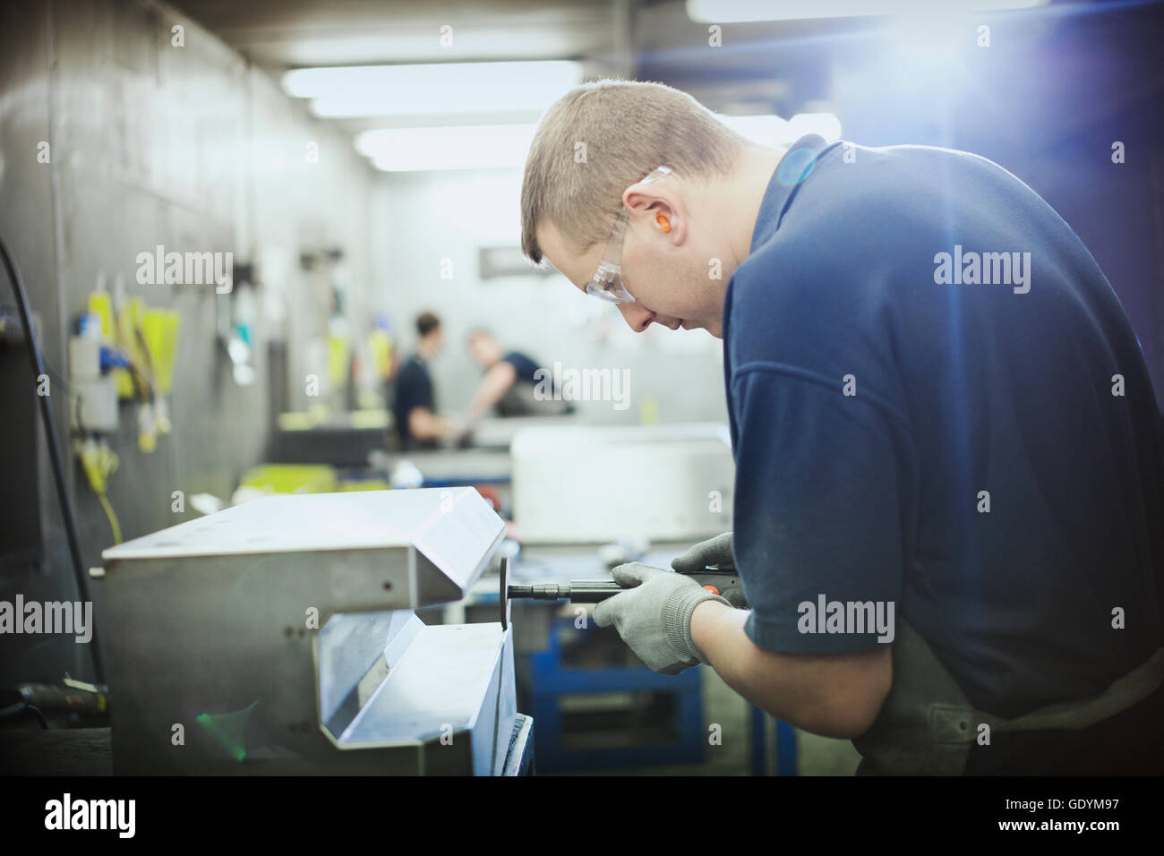 Worker using machinery in steel factory Stock Photo - Alamy