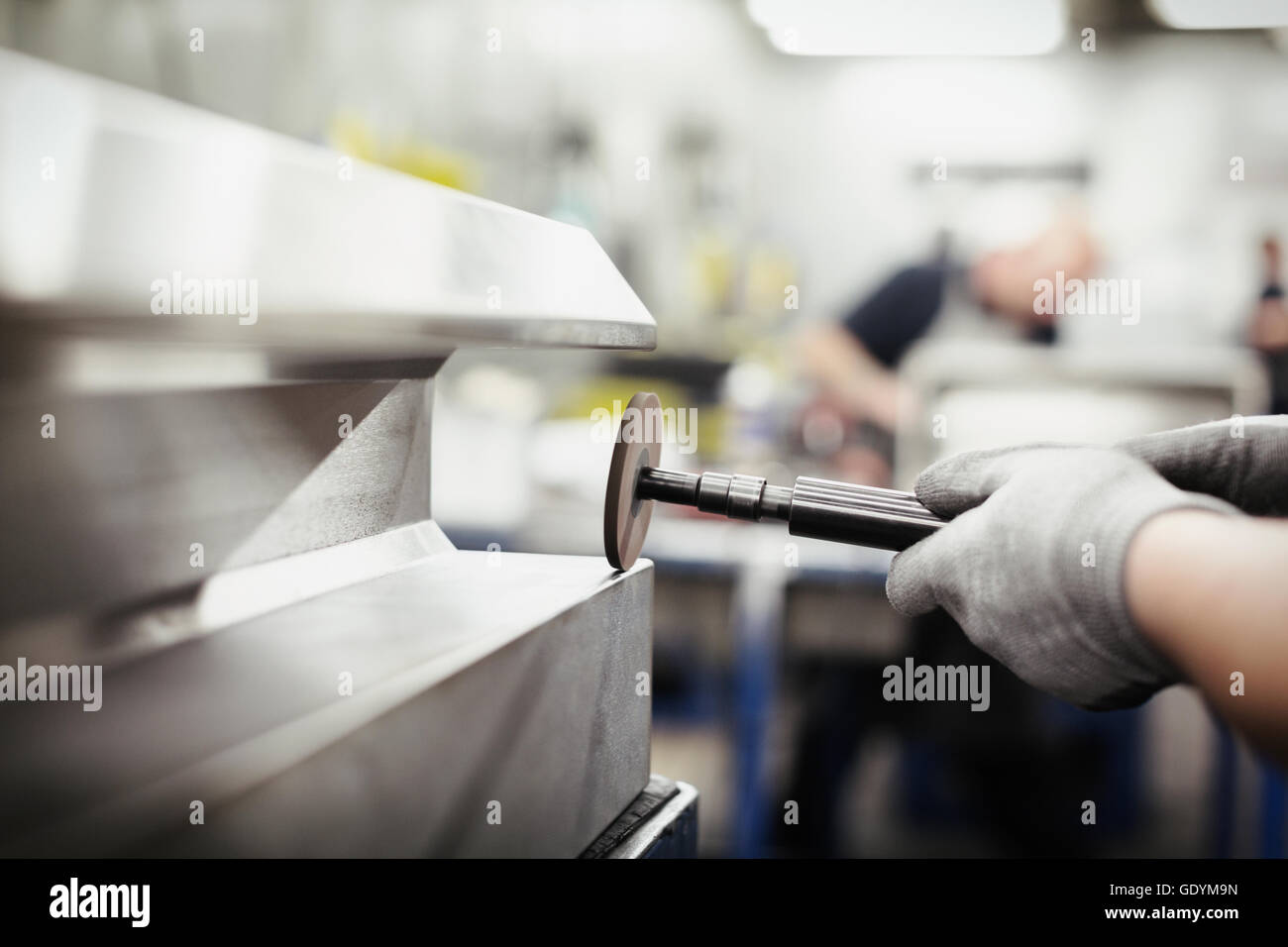 Worker using sander on steel in steel factory Stock Photo - Alamy