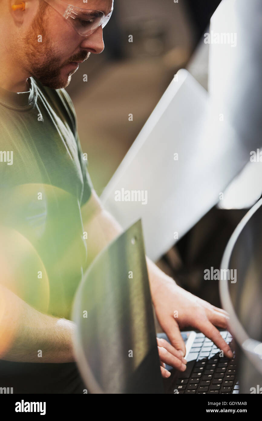 Worker using computer in steel factory Stock Photo - Alamy