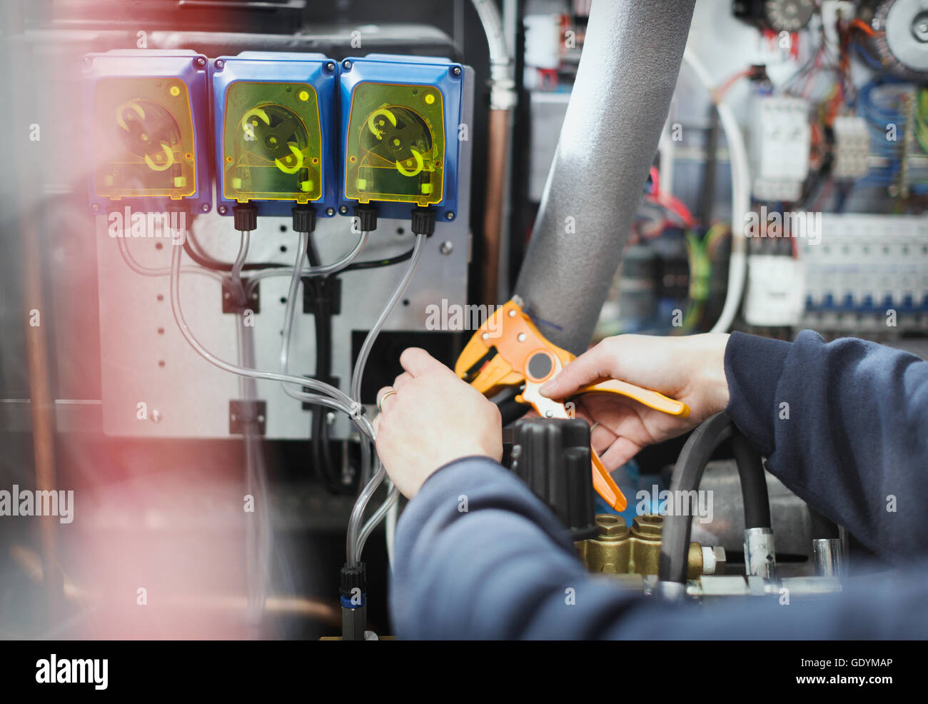 Worker using tool on machinery in steel factory Stock Photo - Alamy
