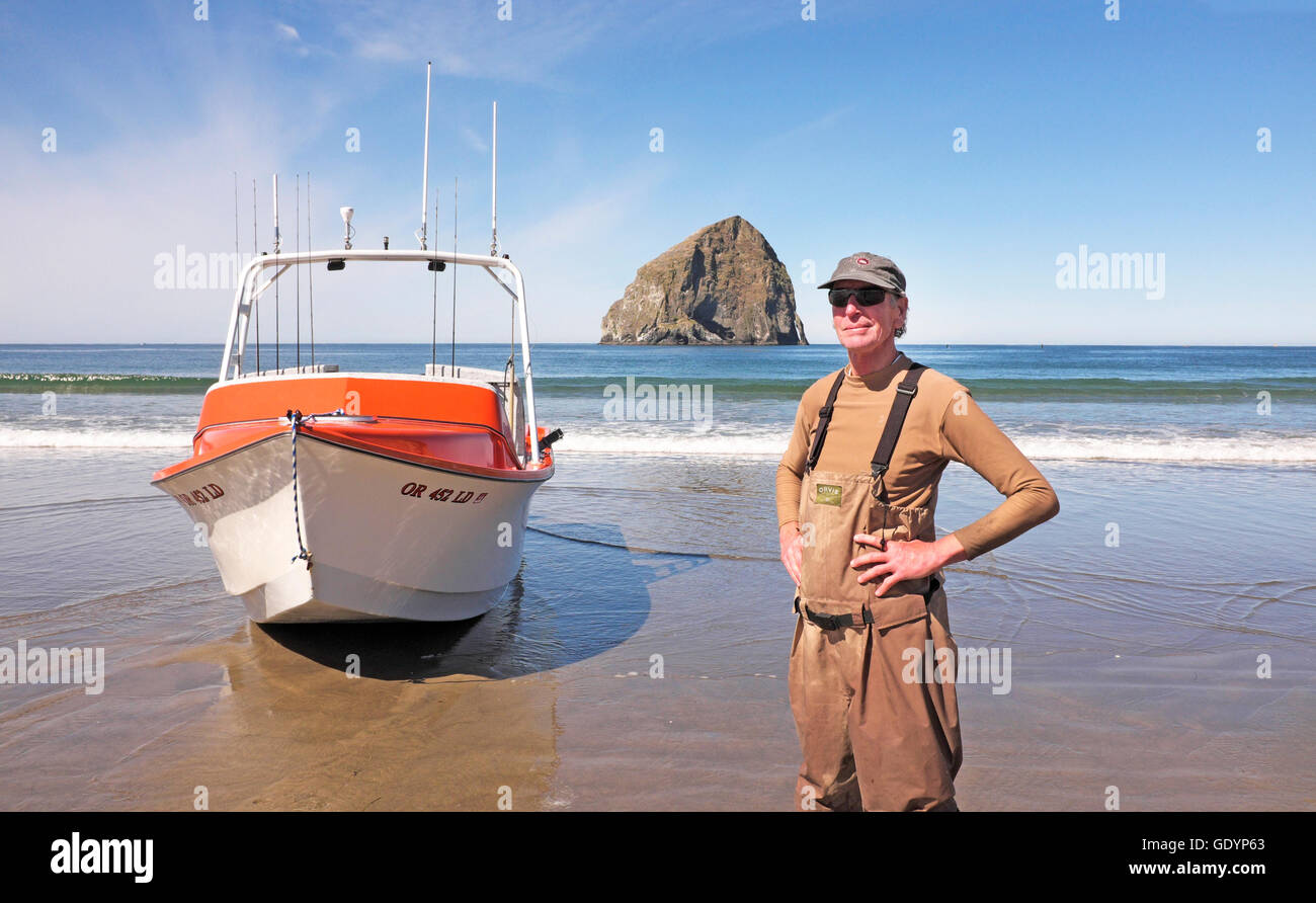 A dory fisherman stands near his boat on the beach at Pacific City ...