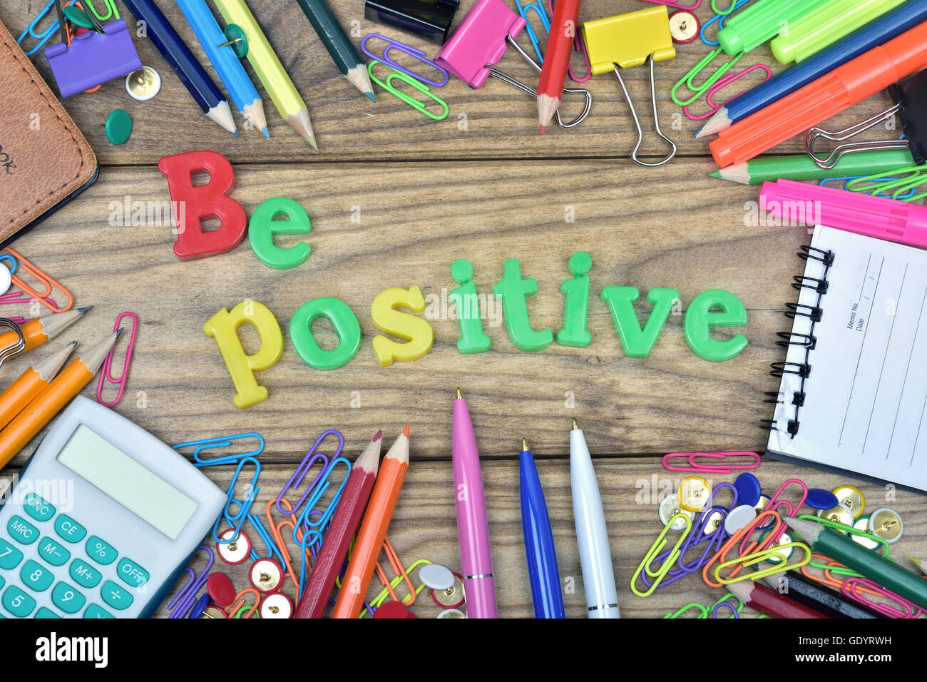 Be positive and office tools on wooden table Stock Photo - Alamy