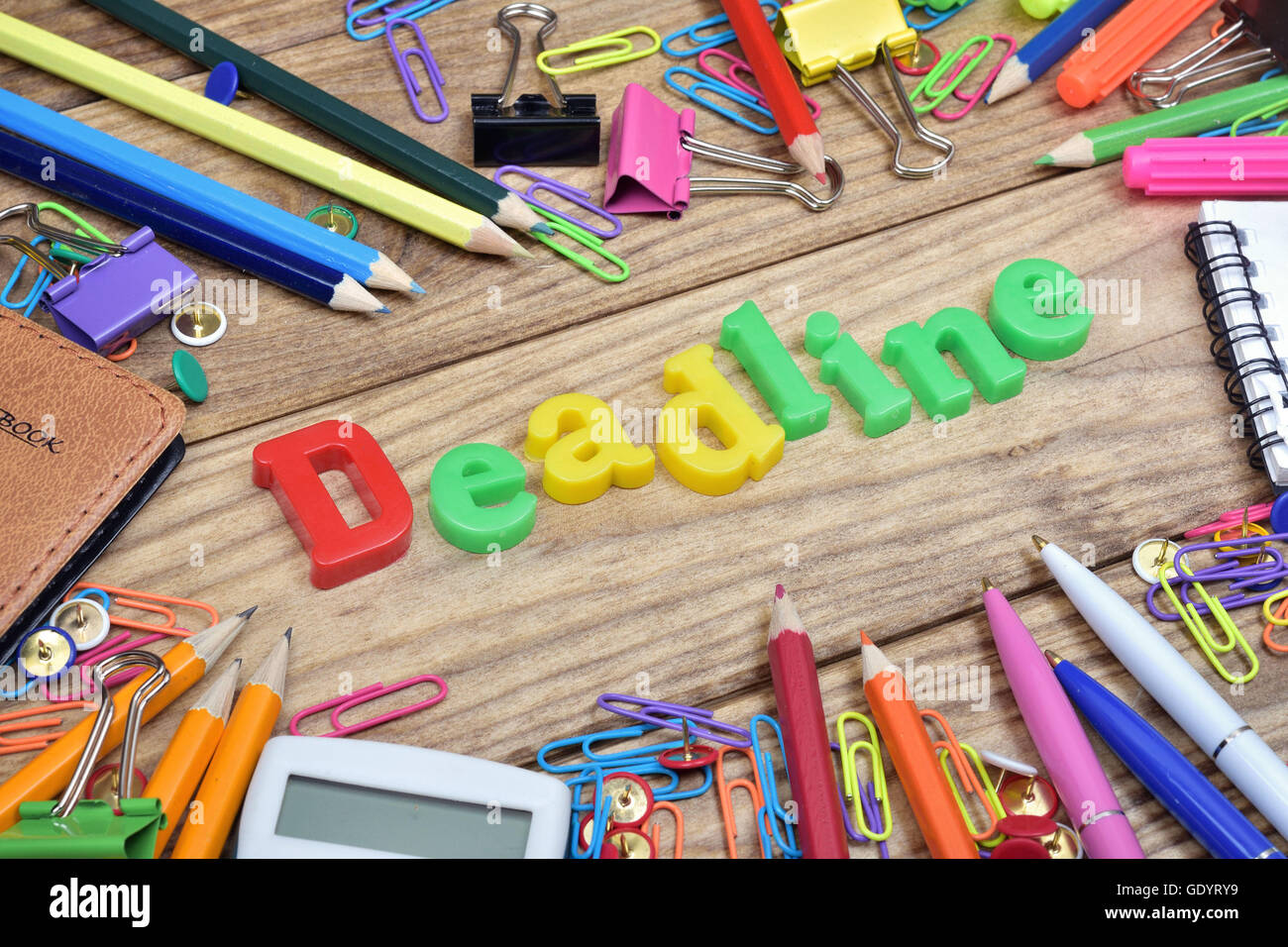 Deadline word and office tools on wooden table Stock Photo - Alamy