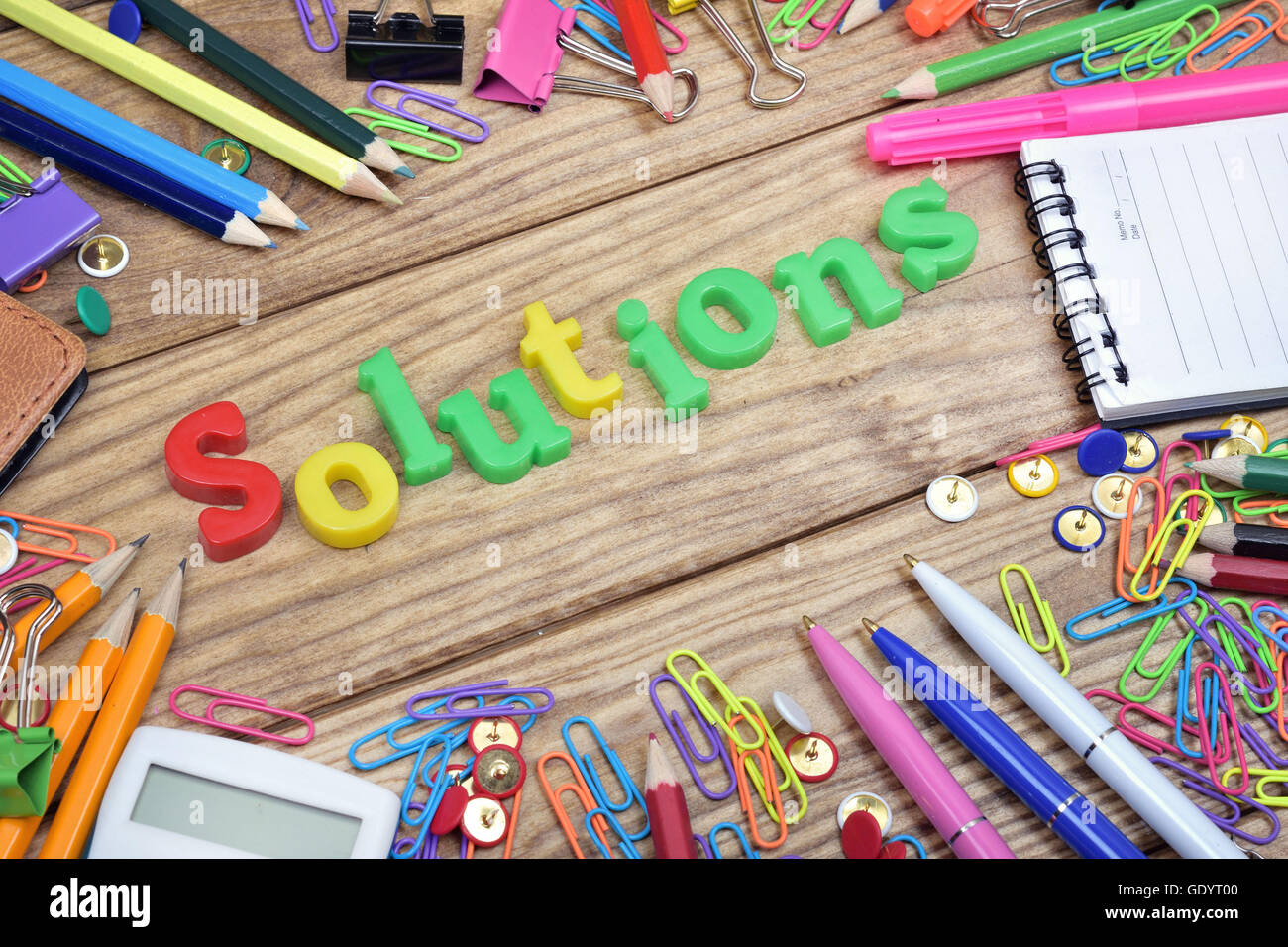 Solutions word and office tools on wooden table Stock Photo - Alamy