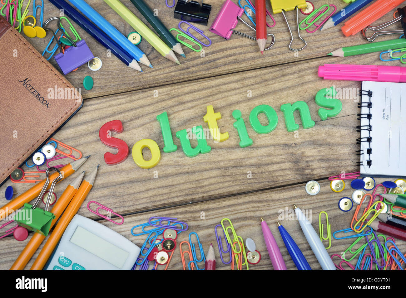 Solutions word and office tools on wooden table Stock Photo - Alamy