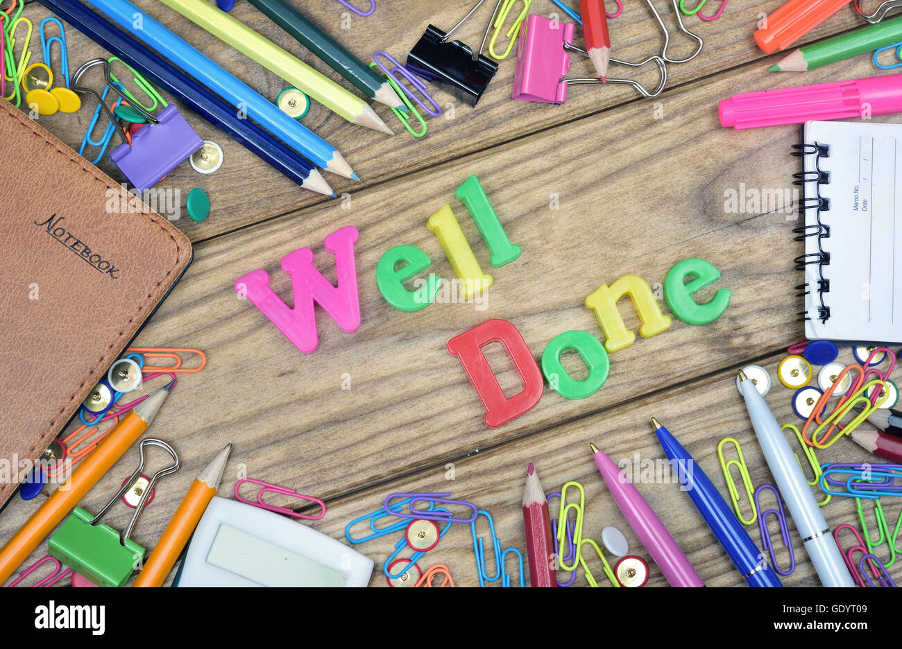 Well Done word and office tools on wooden table Stock Photo - Alamy