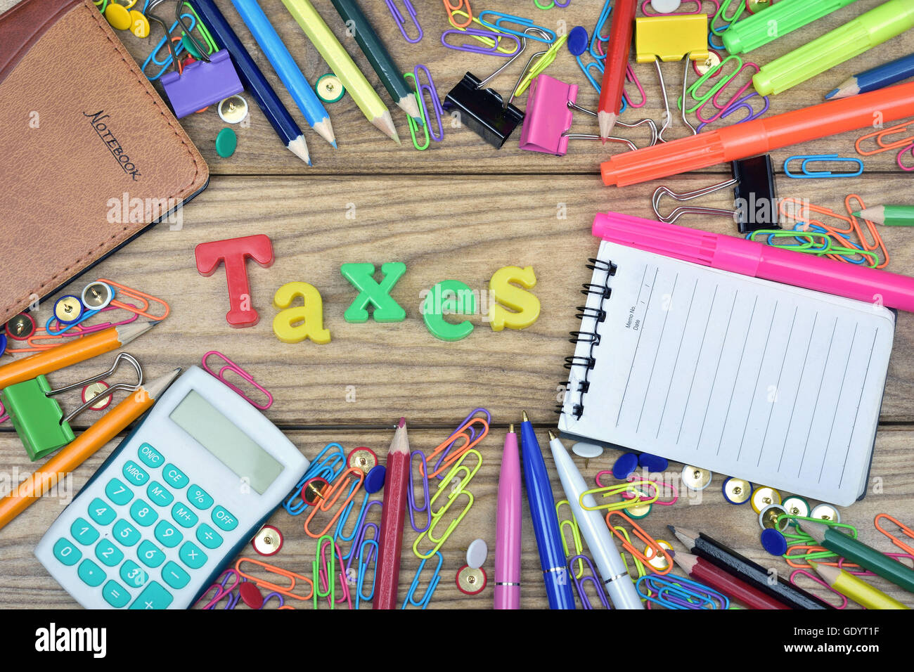 Taxes word and office tools on wooden table Stock Photo - Alamy