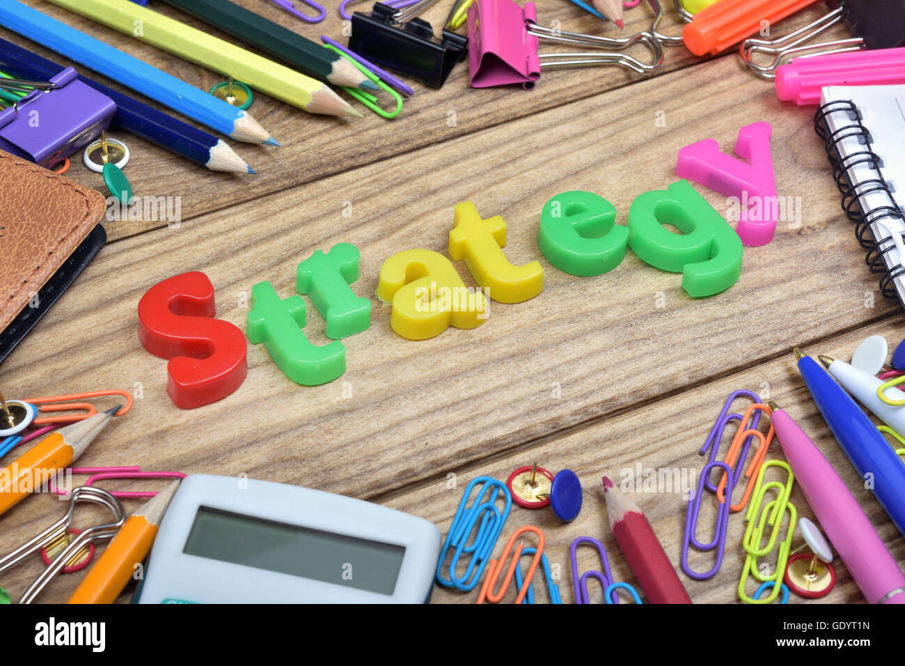 Strategy word and office tools on wooden table Stock Photo - Alamy