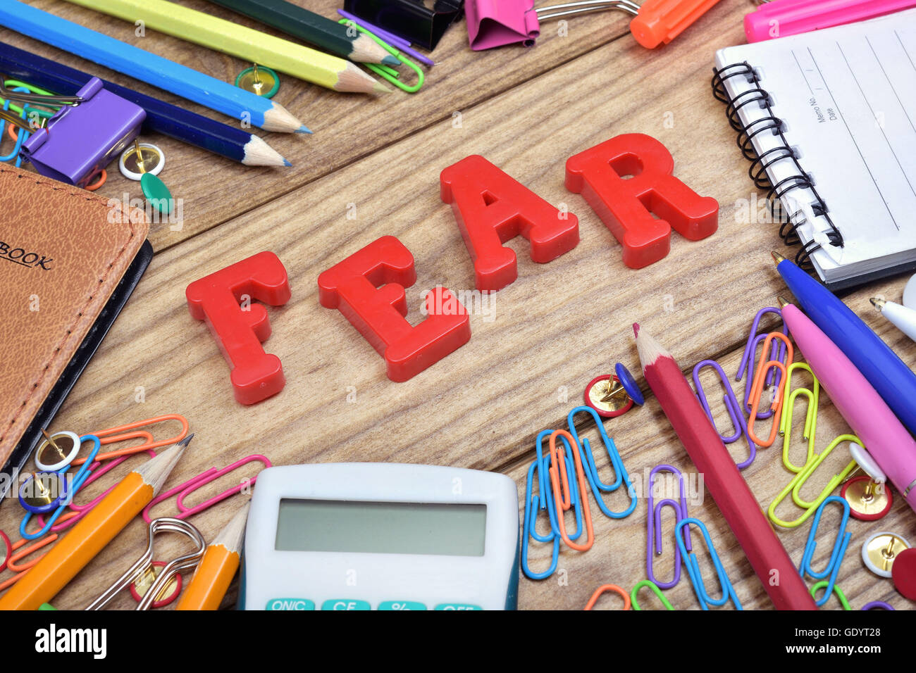 Fear word and office tools on wooden table Stock Photo - Alamy