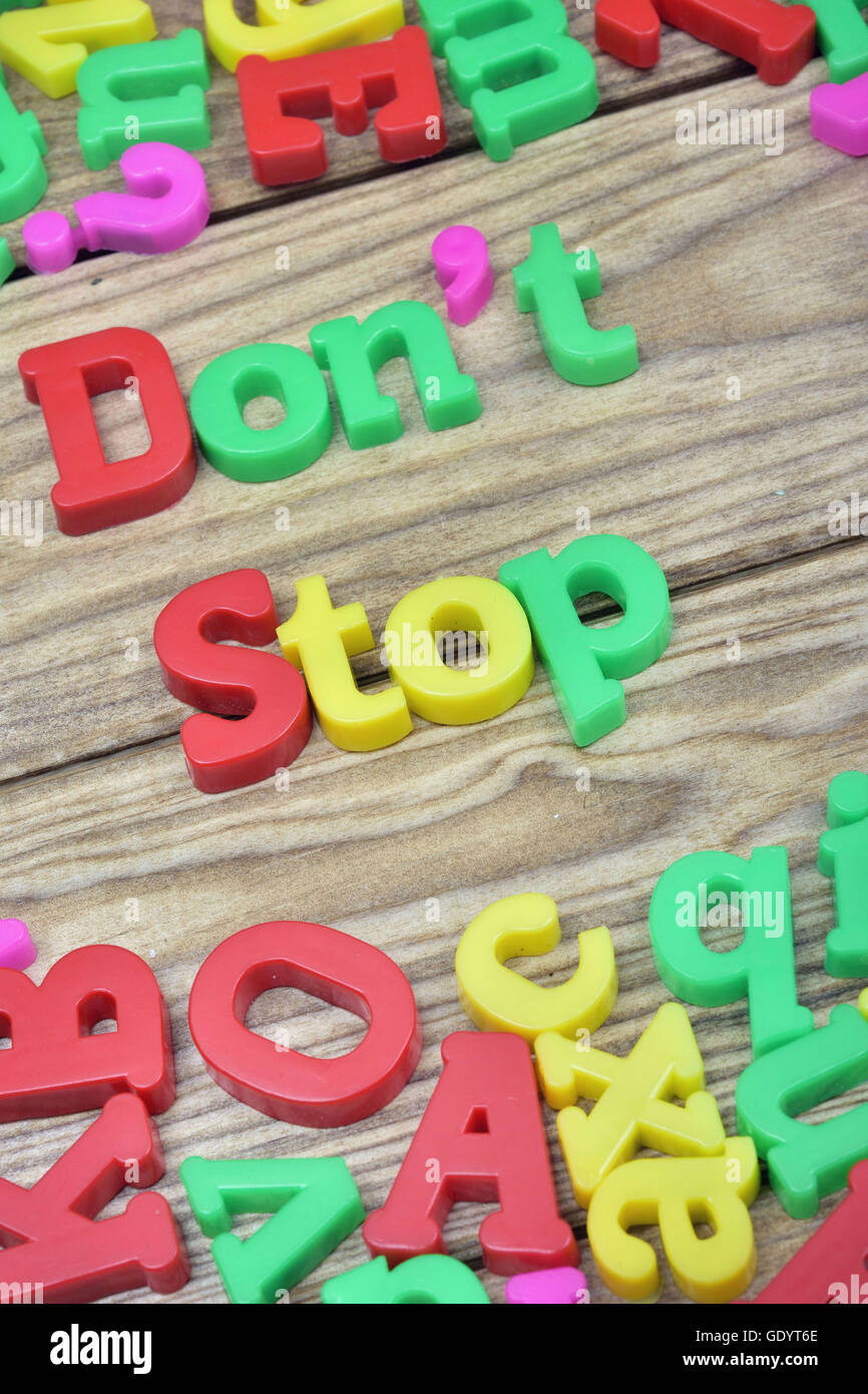 Don't Stop word on wooden table Stock Photo - Alamy