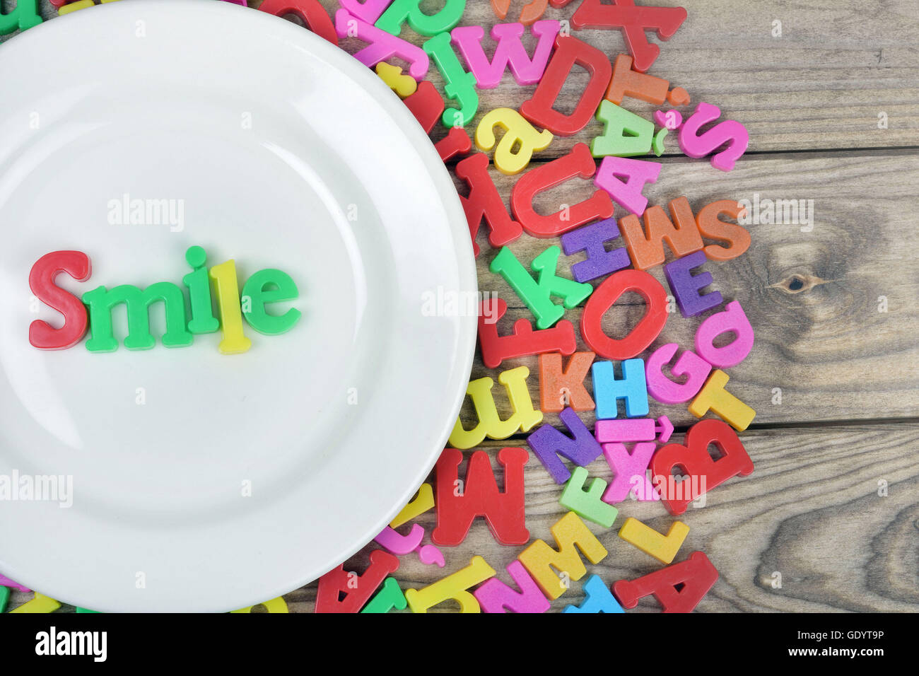 Smile word on white plate and magnetic letters Stock Photo - Alamy