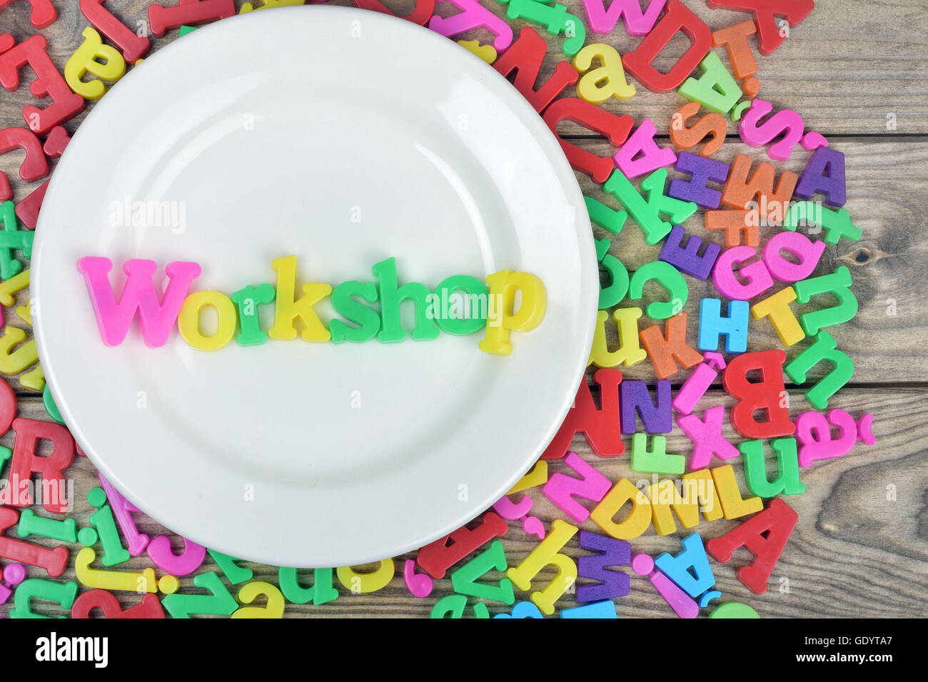 Workshop word on white plate and magnetic letters Stock Photo - Alamy