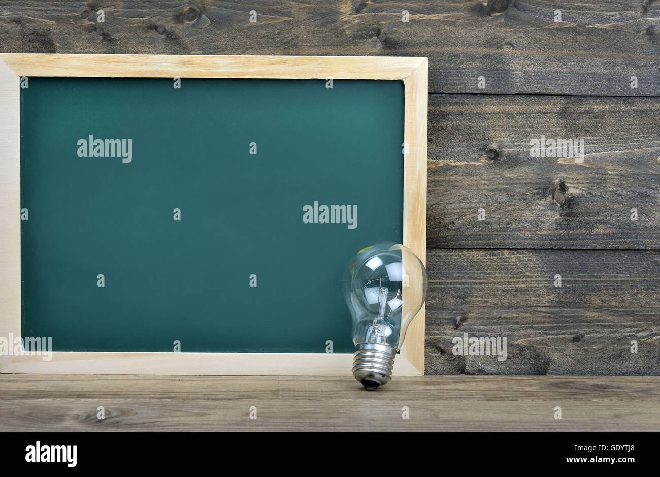 School board and bulb on wooden table Stock Photo - Alamy