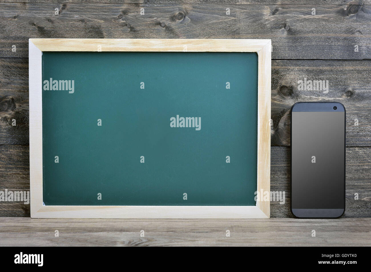School board and smartphone on wooden table Stock Photo - Alamy