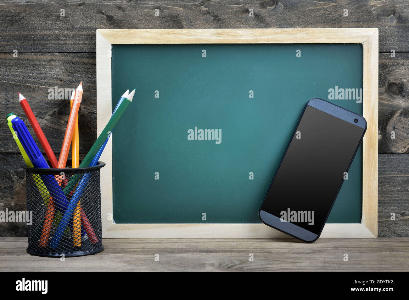 School board and smartphone on wooden table Stock Photo - Alamy