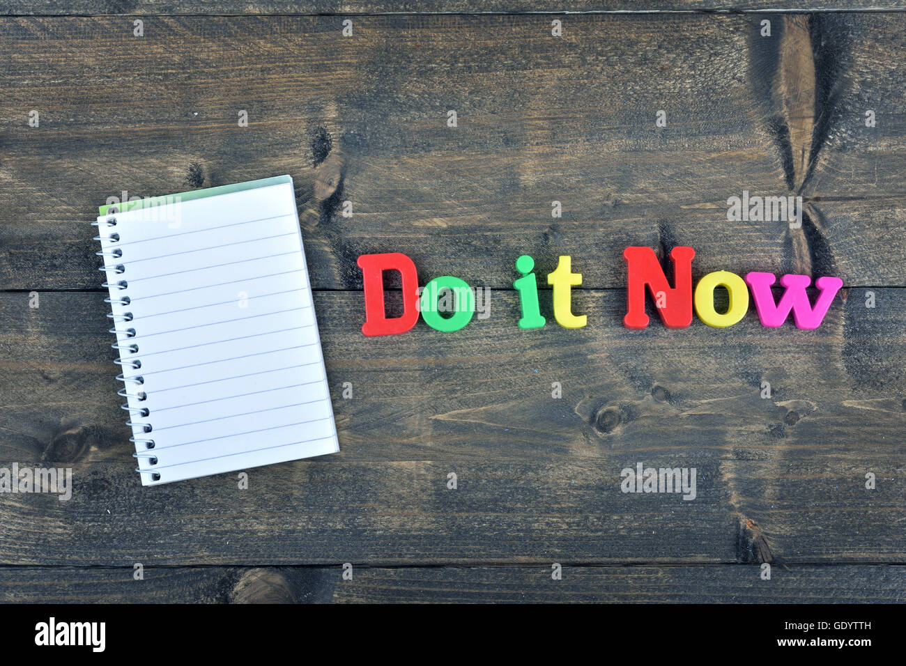 Do it now word on wooden table Stock Photo - Alamy