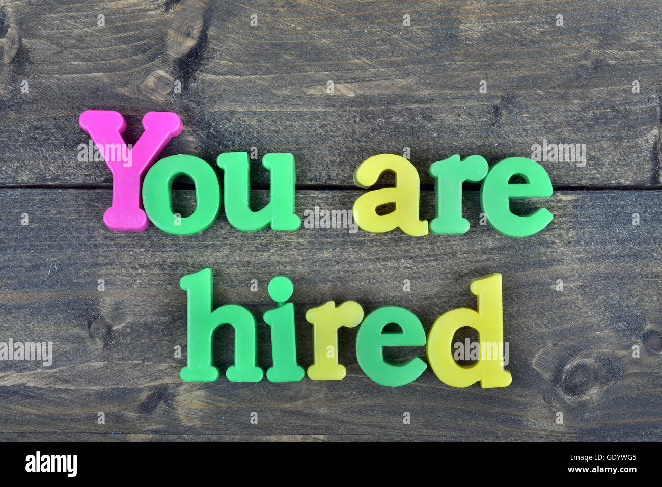 You are hired word on wooden table Stock Photo - Alamy