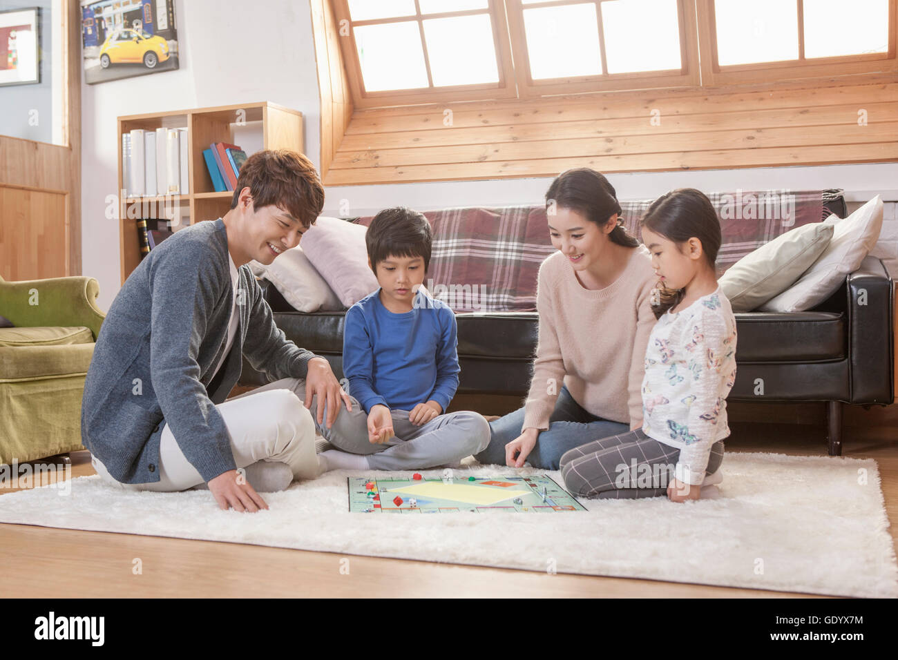 Harmonious family playing a board game together in living room Stock ...
