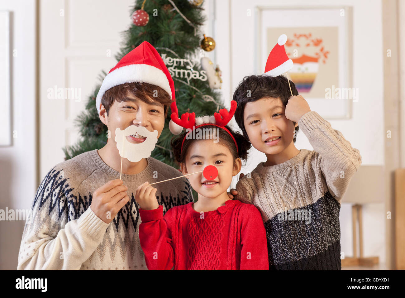 Portrait of smiling father, daughter and son wearing Christmas costumes ...