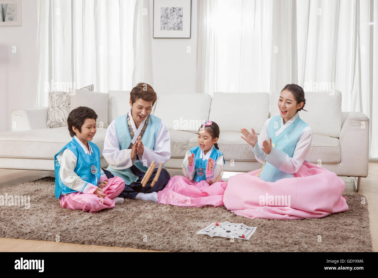 Family in traditional korean clothes playing yut hi-res stock ...
